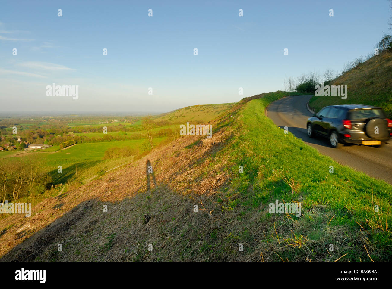 Car drives up a steep hill in the South downs on the Ditchling Road ...