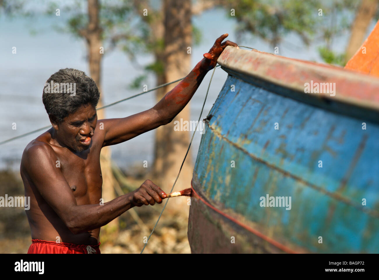Southern Thailand Moken sea gypsy fisherman painting his boat Stock ...