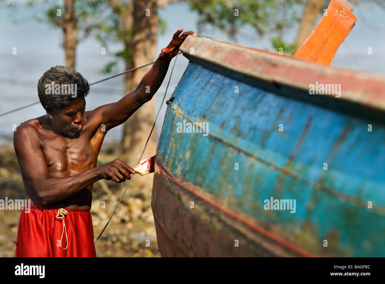 Southern Thailand Moken sea gypsy fisherman painting his boat Stock ...