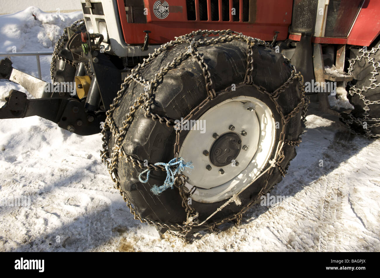 Tractor wheel with snow chains Stock Photo - Alamy