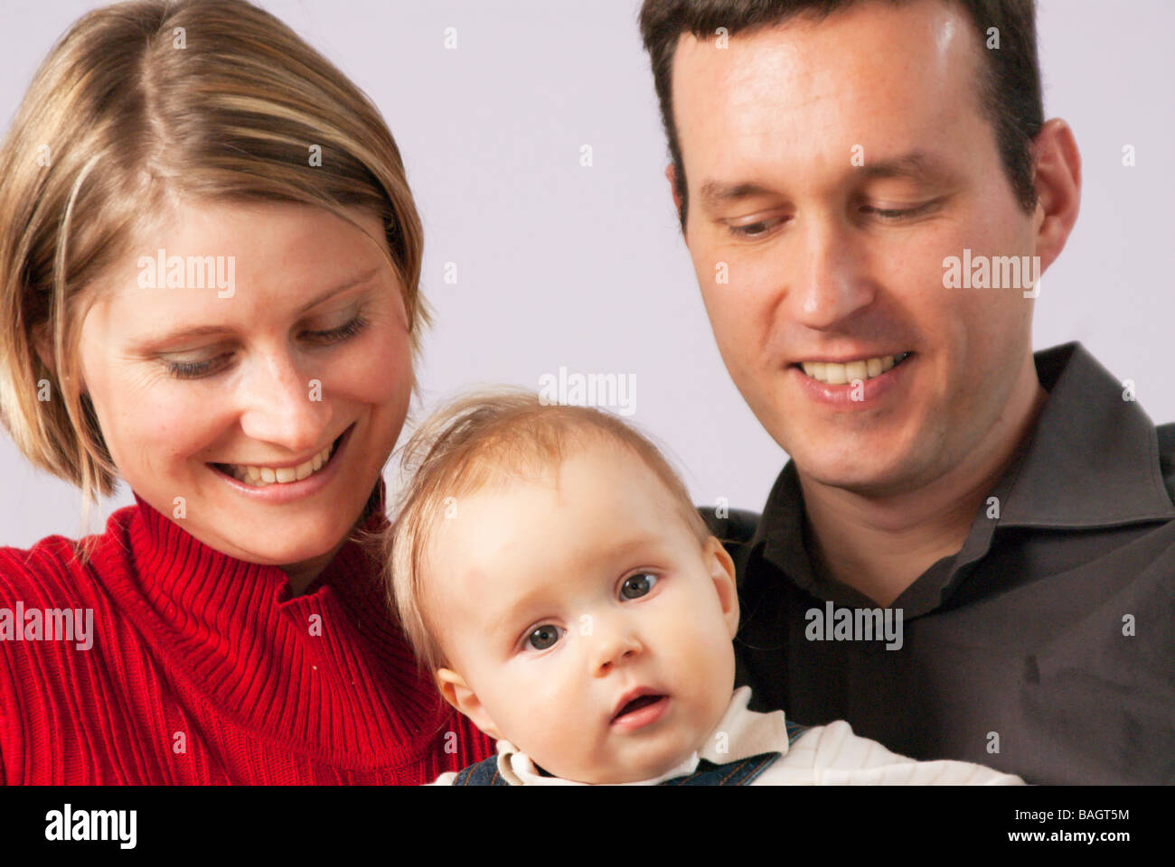 Portrait of parents look happyly at their child Stock Photo - Alamy