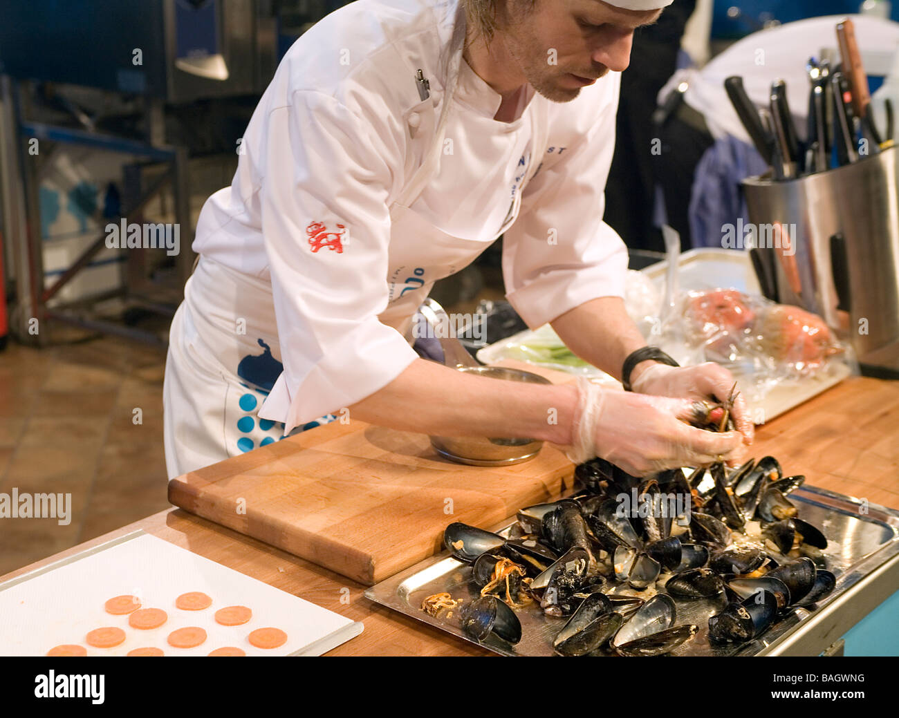 Cook carefully cleans and sorts sea mussels Stock Photo - Alamy