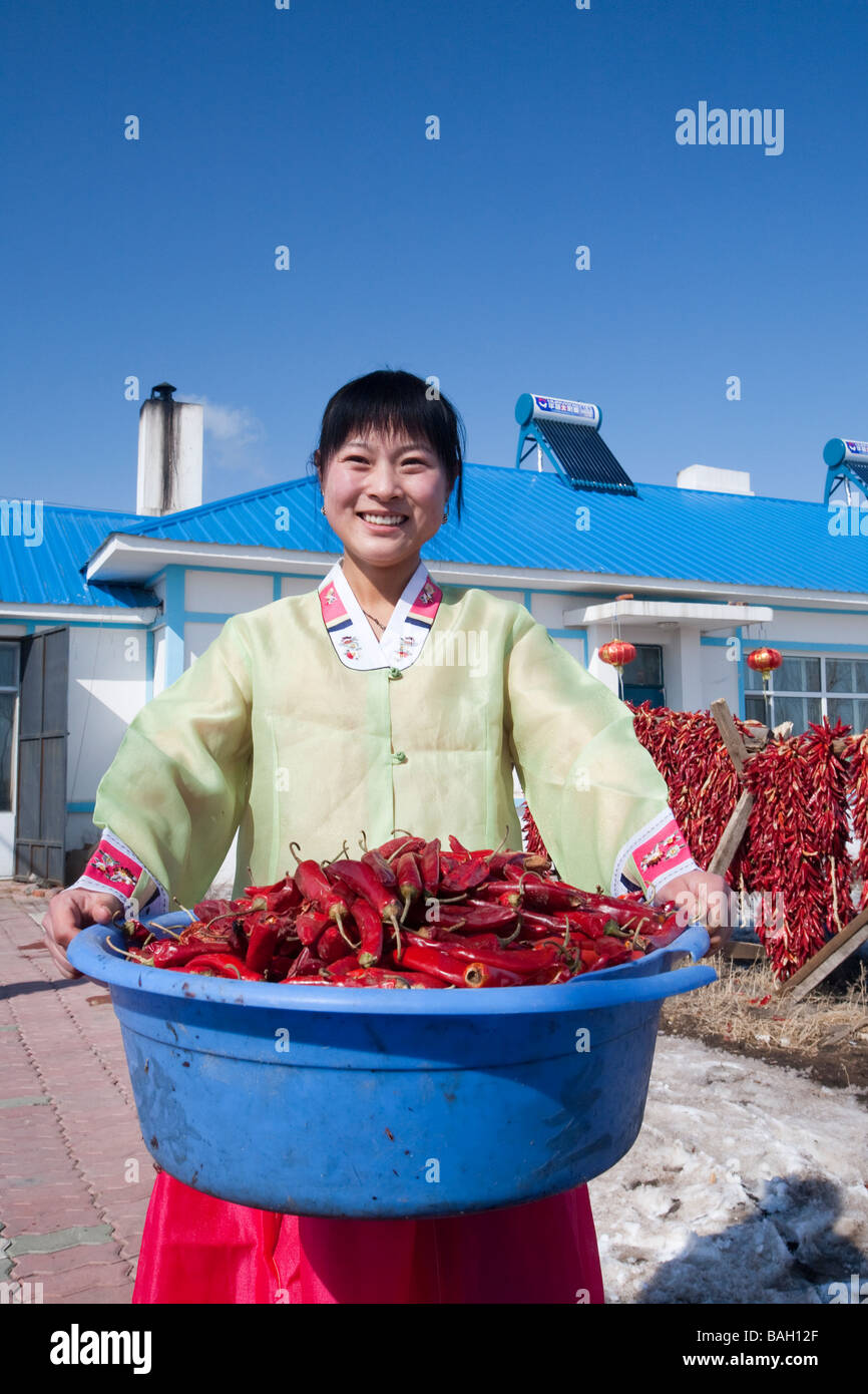 A chinese farmer showing off her crop of chilli peppers Stock Photo - Alamy