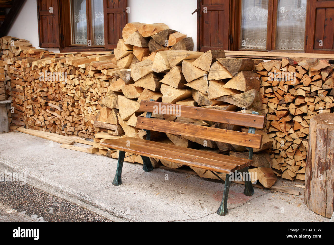 Bench above of stacked logs in Italian Dolomiti Stock Photo - Alamy