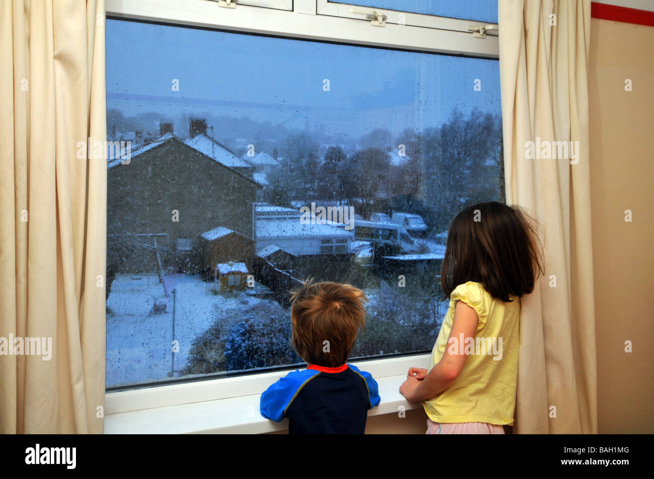 Children look out a window after snowfall, Britain, UK Stock Photo - Alamy