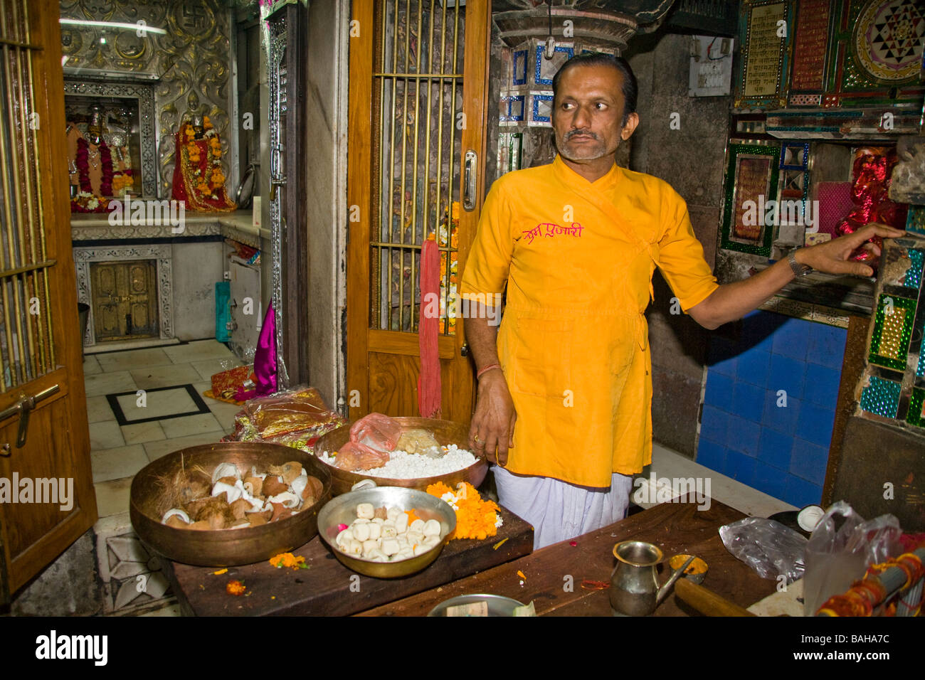 Temple helper beside offering bowls, Sachiya Mata Temple, Osian, near ...