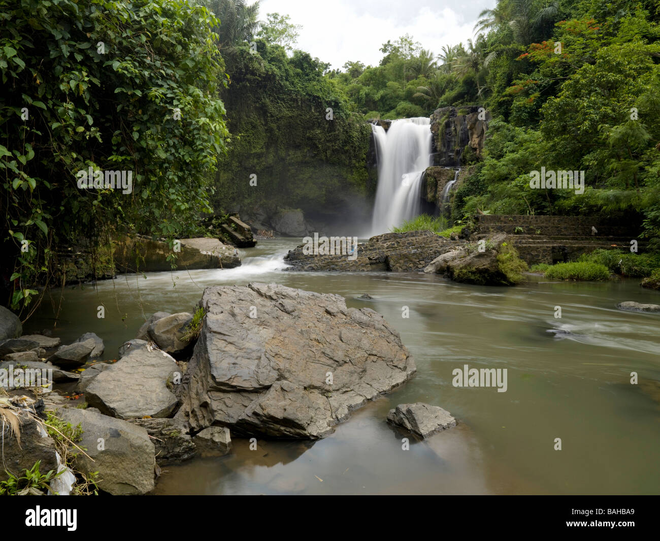 Waterfall flowing into a river, Bali, Indonesia Stock Photo - Alamy