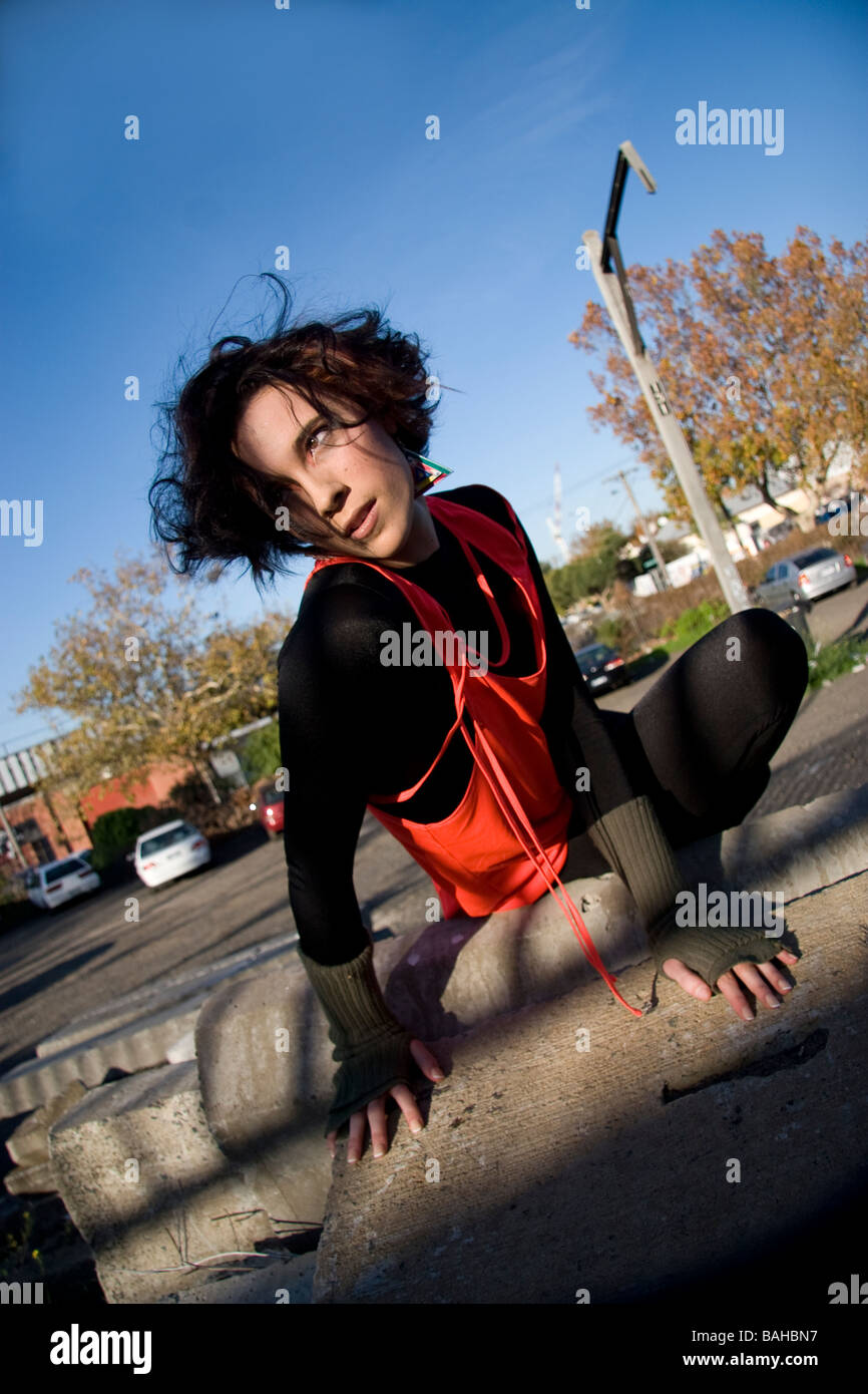 Athletic woman in cat like pose in car park for fashion shoot Stock ...