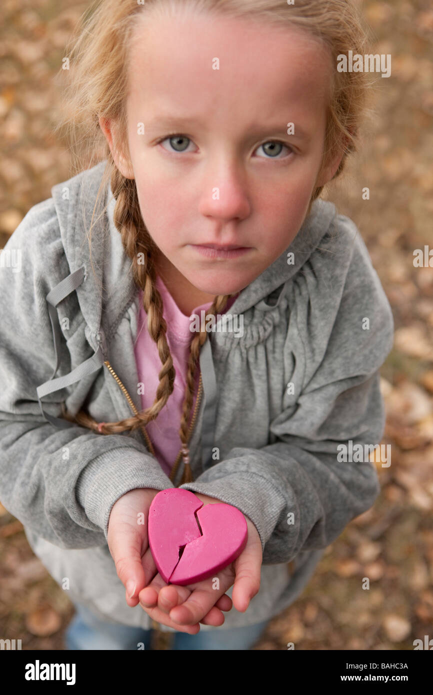 Girl holding broken heart Stock Photo - Alamy