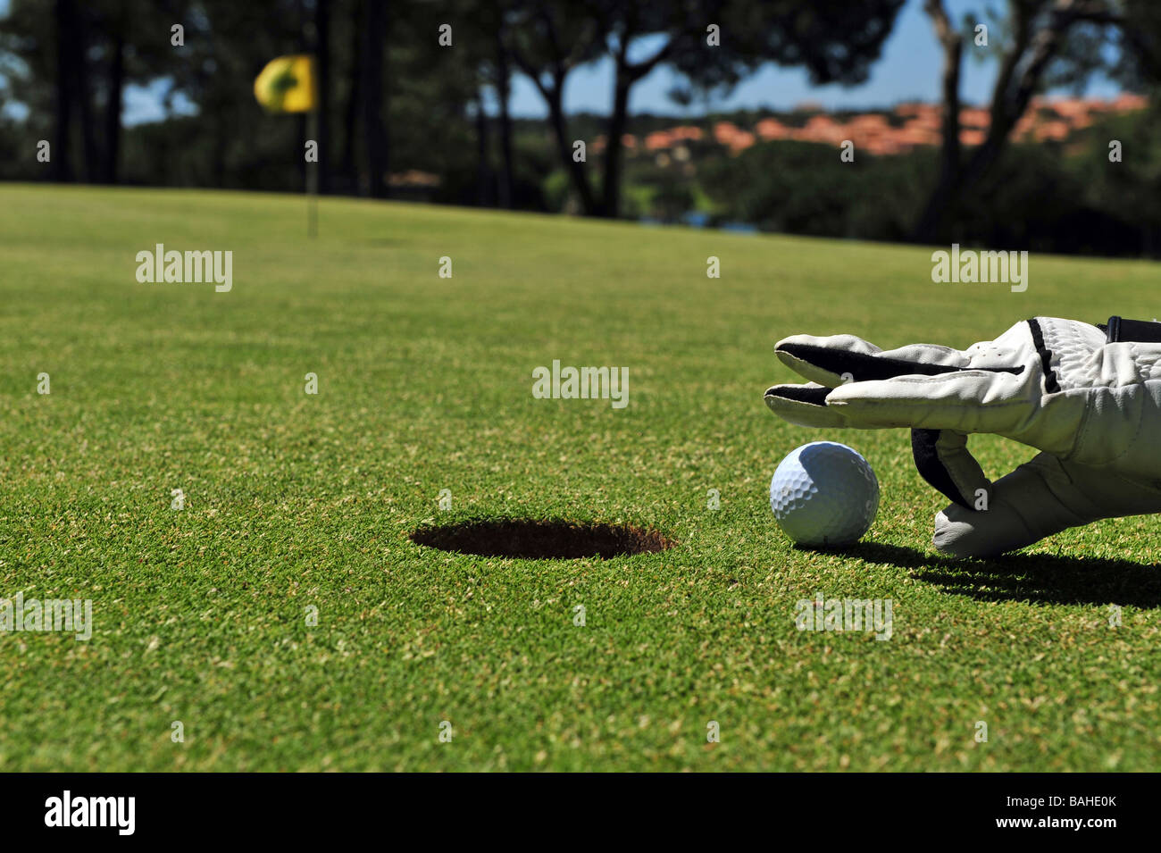 Flicking a golf ball into the hole Stock Photo - Alamy