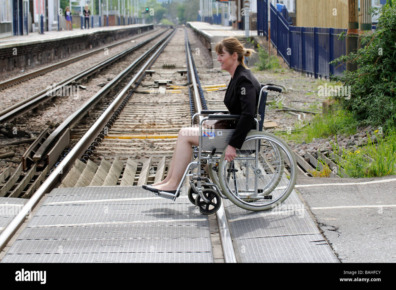Disabled woman wheelchair user crossing railway line to reach the far ...