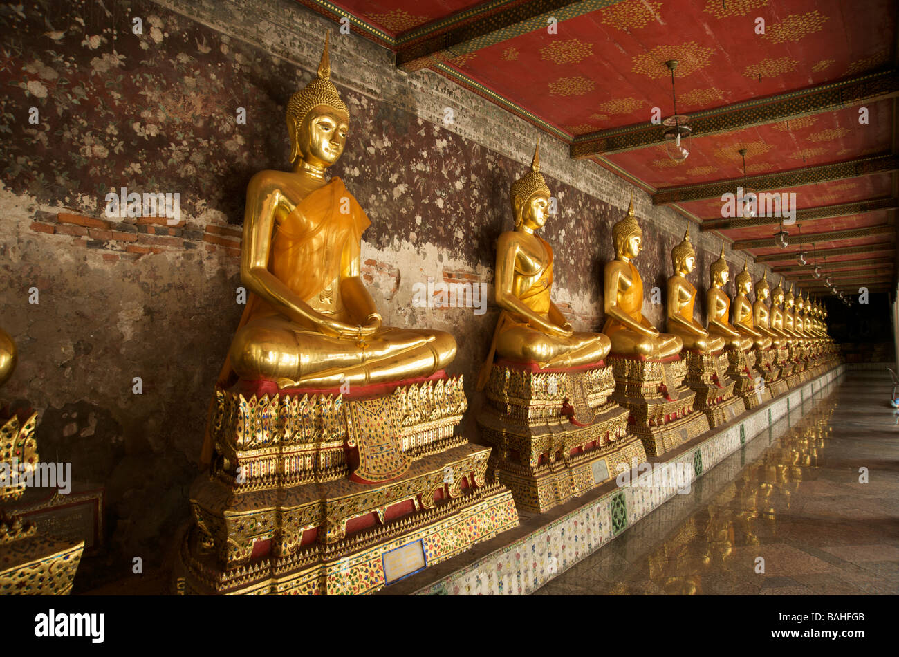 Gold Buddha statues line the galleries that encircle the main building ...