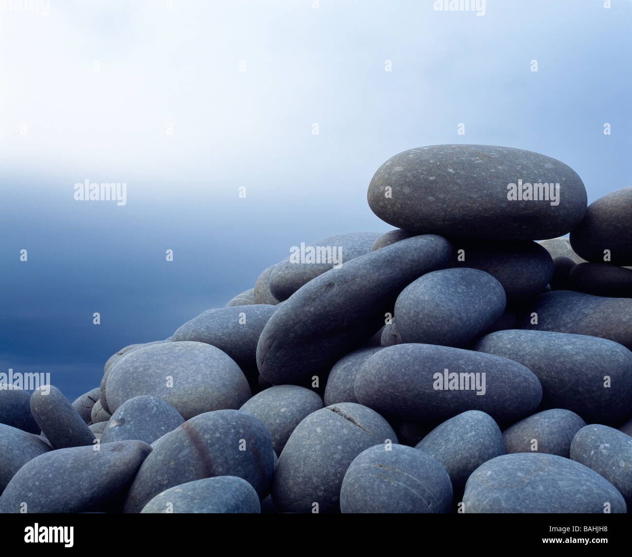 Stacked pebbles at the seaside under a grey sky. Westward Ho! Pebble ...