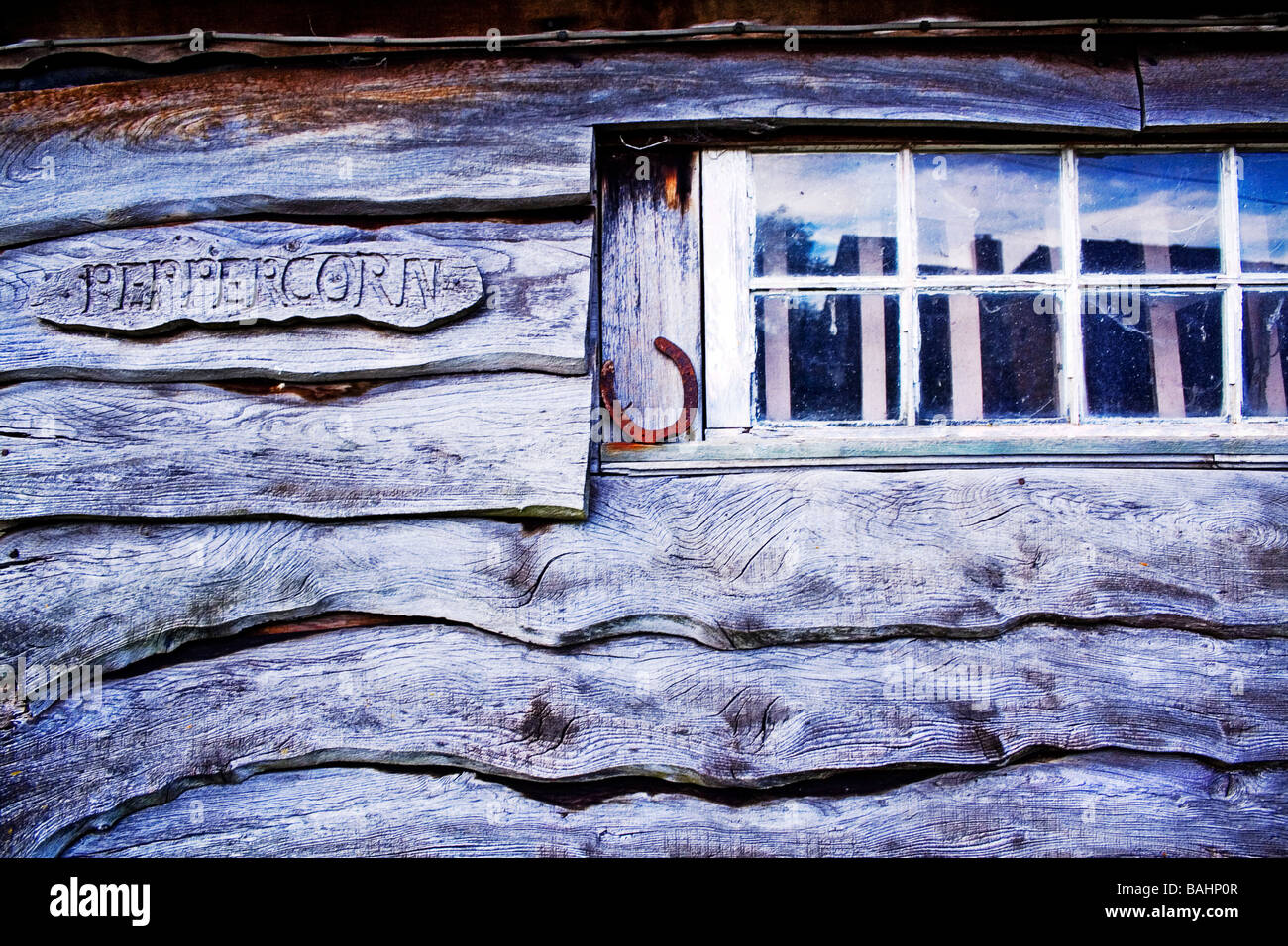 old wooden slatted barn stable with name plaque and horses shoe up ...