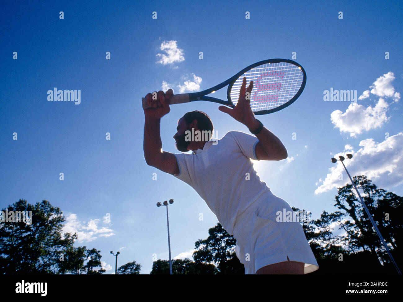 Male tennis player hitting the ball with a racket Stock Photo - Alamy