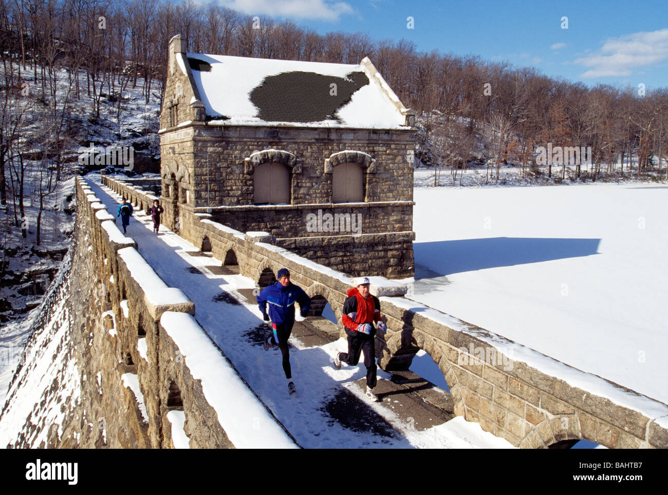 Joggers running in the snow around Lake Scranton Scranton Pennsylvania ...