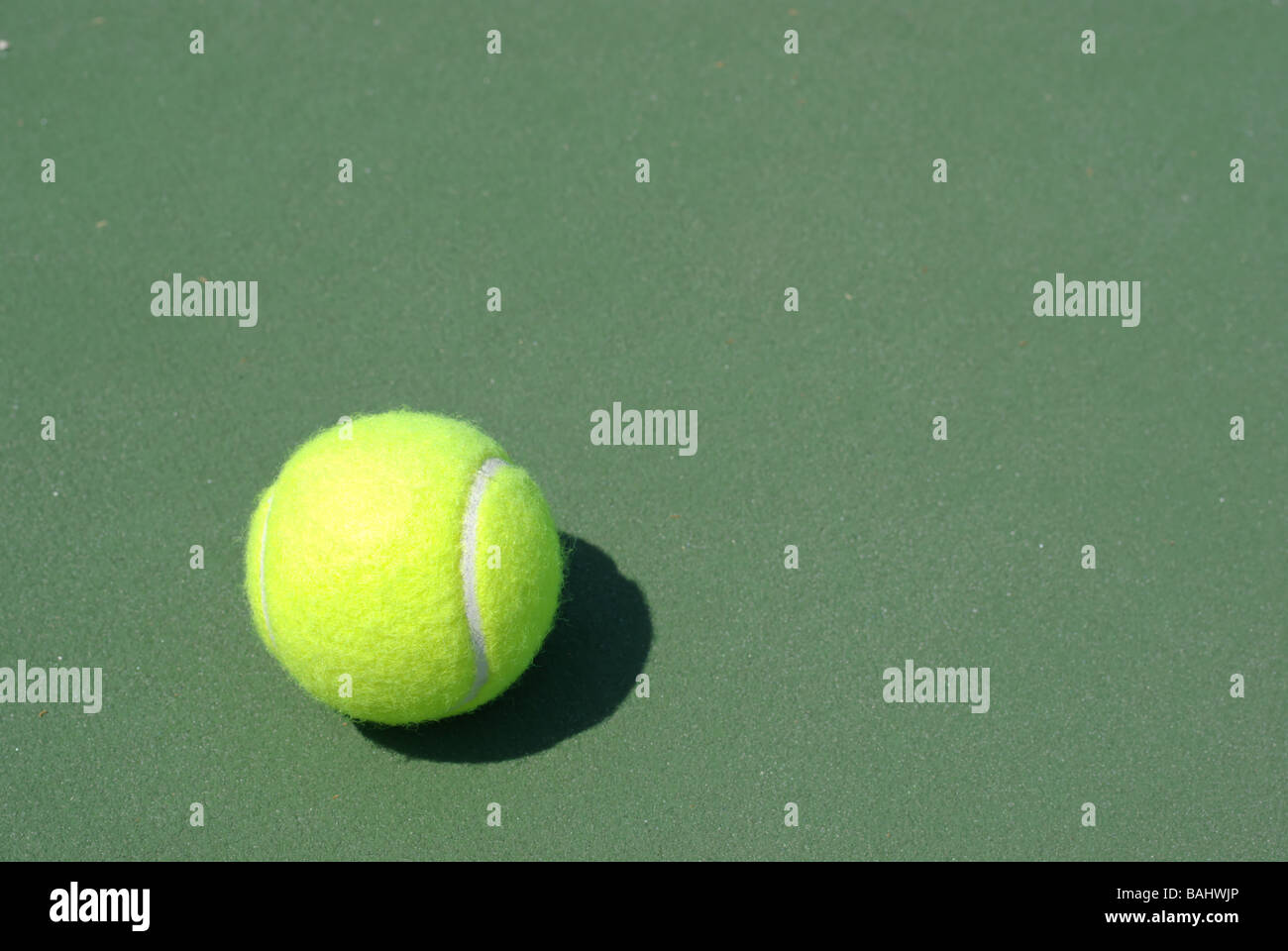 Tennis ball on green hard surface Stock Photo - Alamy