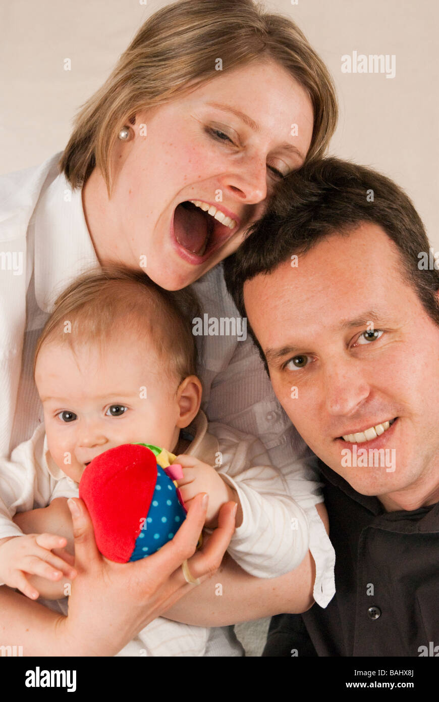 Portrait of happy family playing with their baby Stock Photo - Alamy