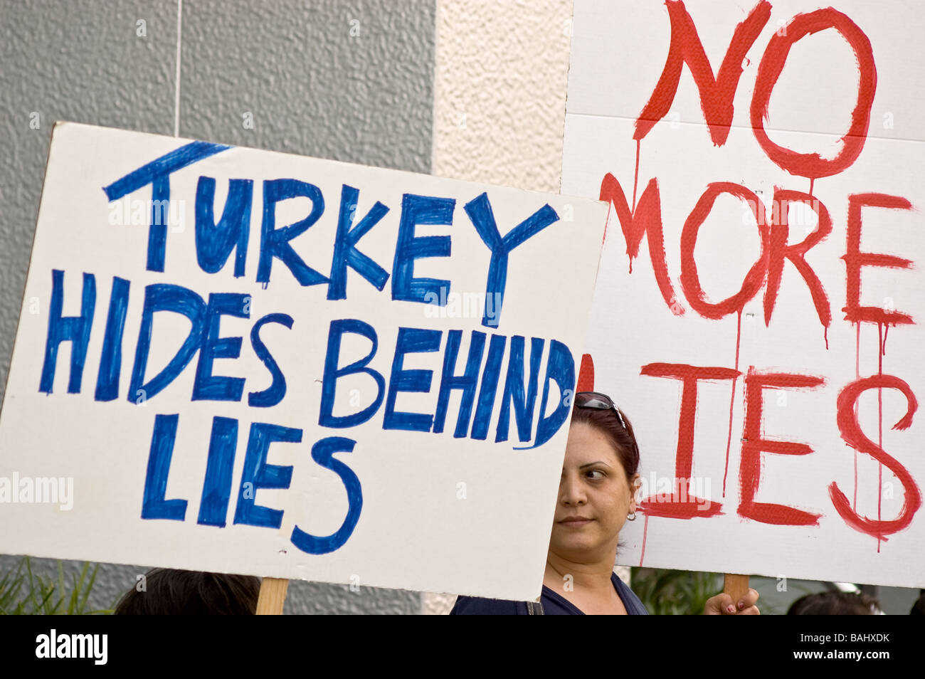 A woman face is half hidden by two anti-Turkey signs; Armenian Genocide ...