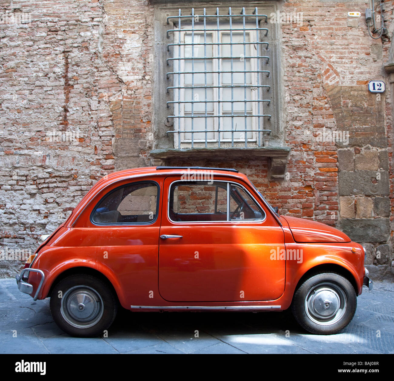 An orange Fiat 500 in an alleyway of Lucca, Tuscany, Italy Stock Photo ...