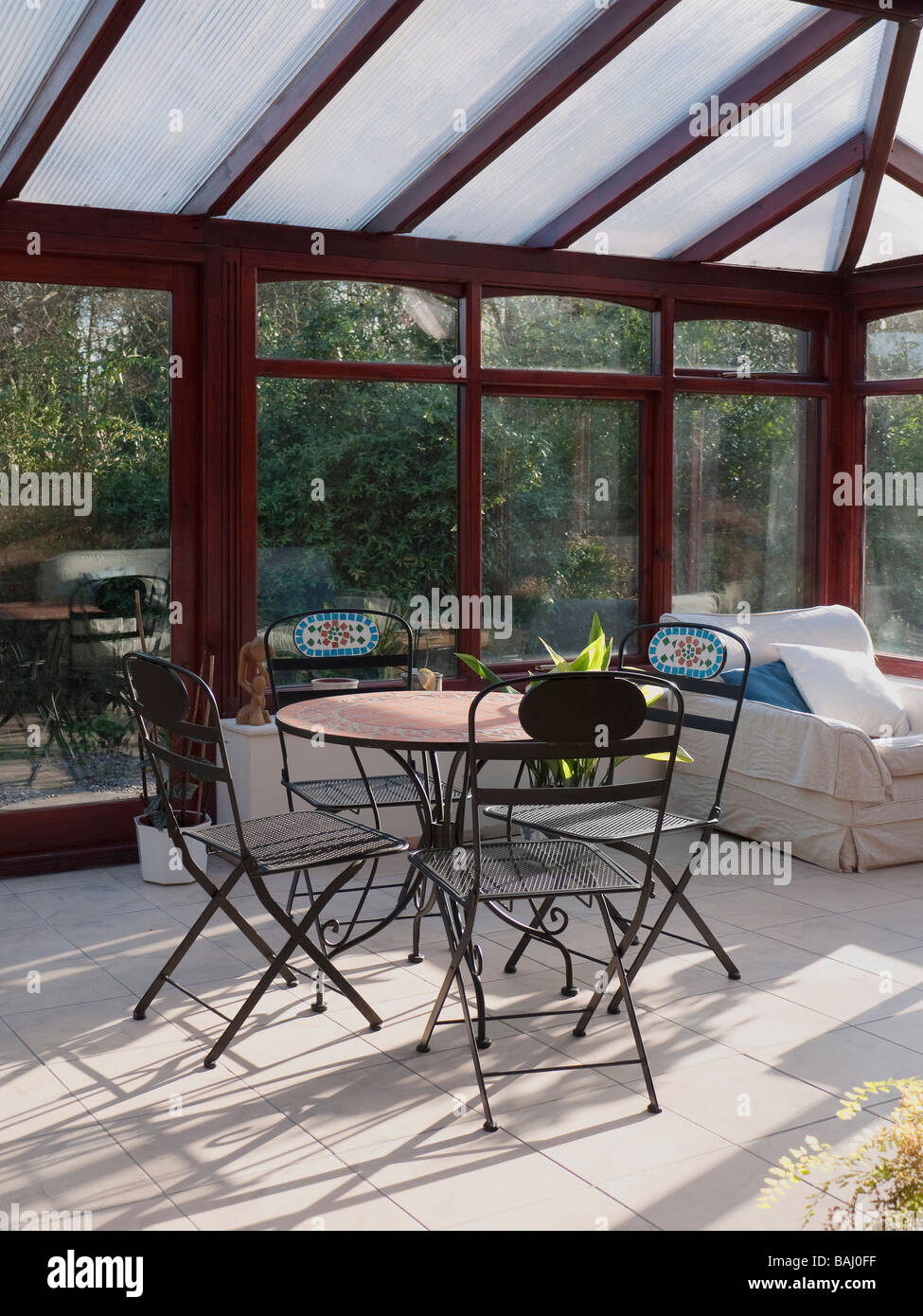 A conservatory with tables chairs plants in room in house next to ...
