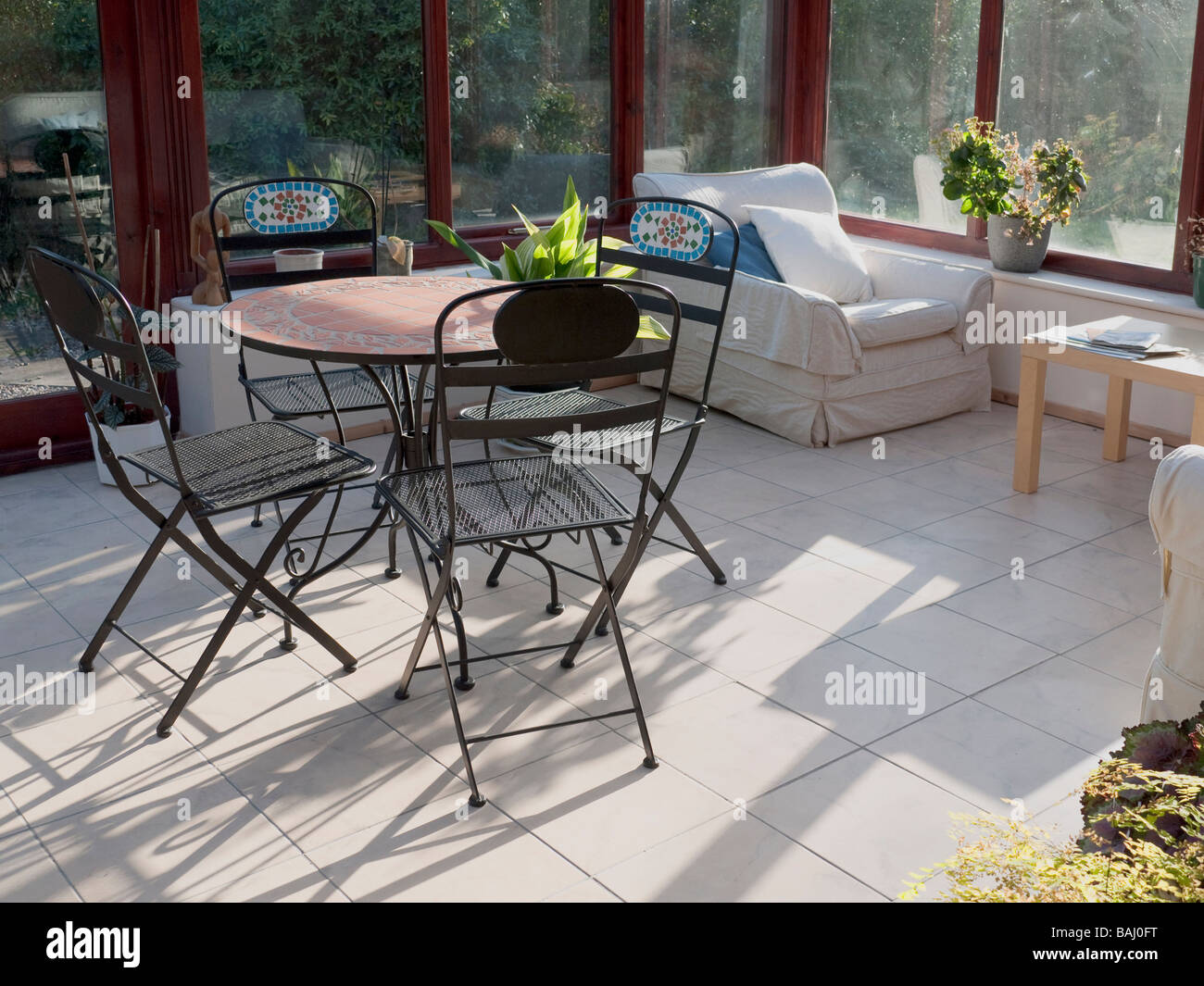 A conservatory with tables chairs plants in room in house next to ...