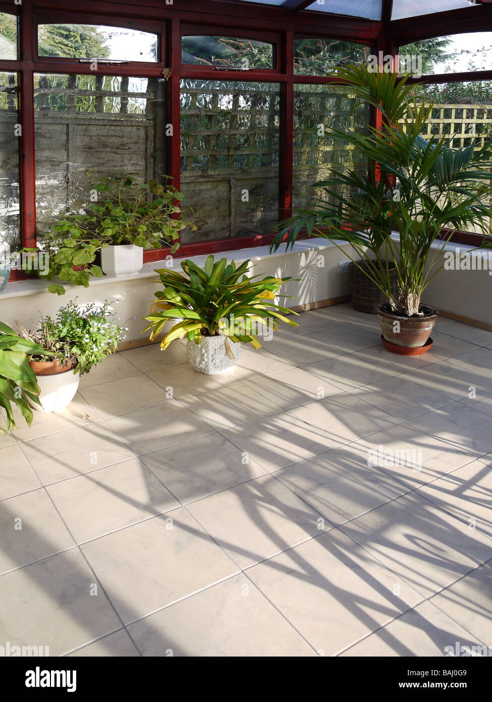 A conservatory with tables chairs plants in room in house next to ...