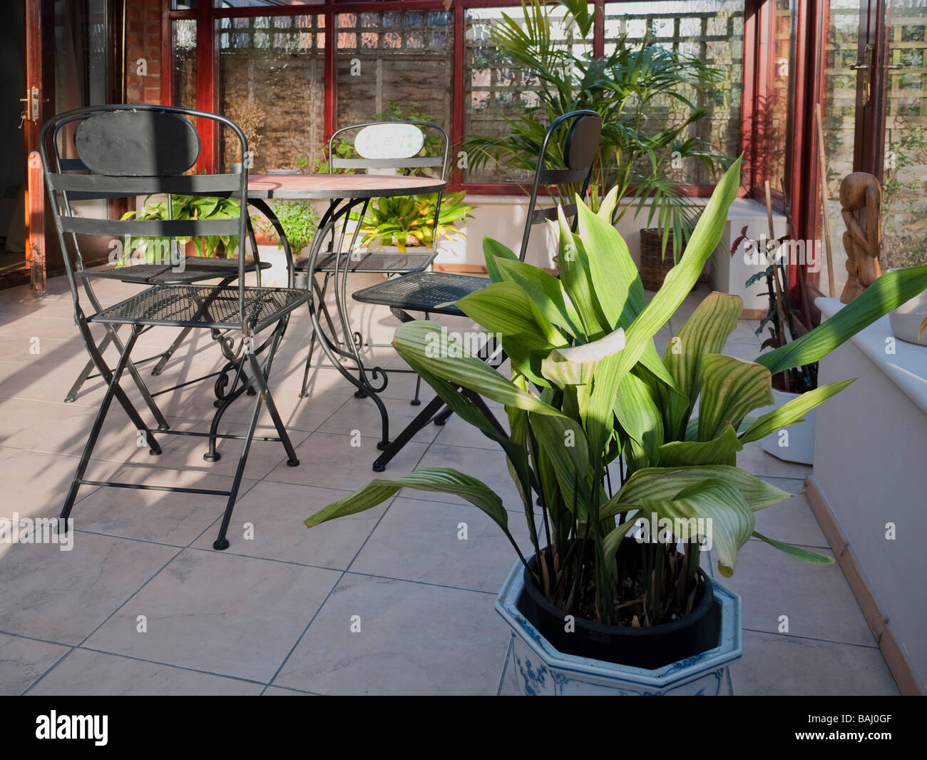 A conservatory with tables chairs plants in room in house next to ...