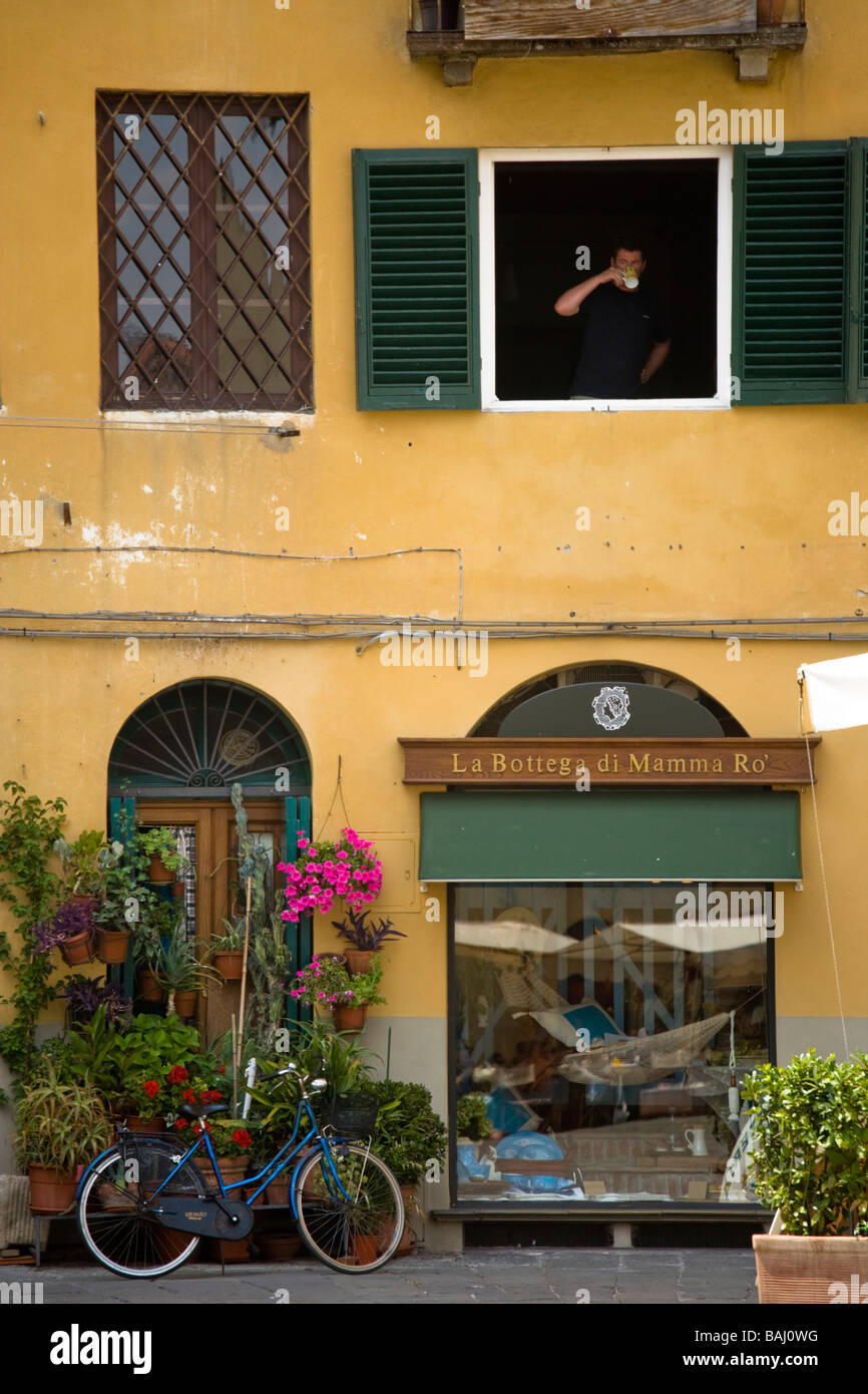A man having a cup of coffee at the window of a building in the Piazza ...