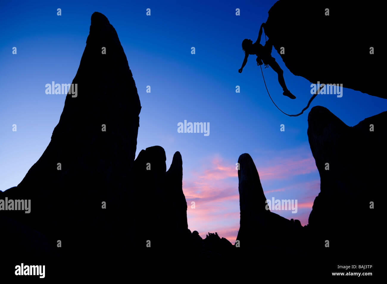 A climber clings to the side of an overhanging cliff in The Sierra ...