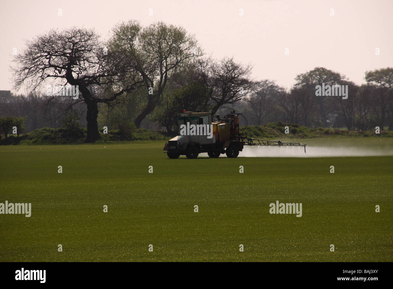 all terrain vehicle fitted with a crop sprayer treating turf on a ...