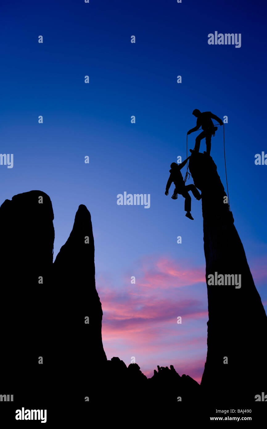 Team of climbers reaching the summit of a rock pinnacle Stock Photo - Alamy