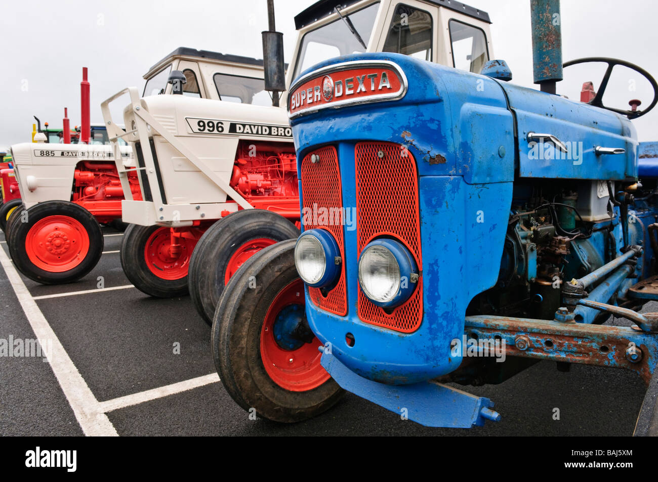 Number of vintage farm tractors lined up in a carpark Stock Photo - Alamy
