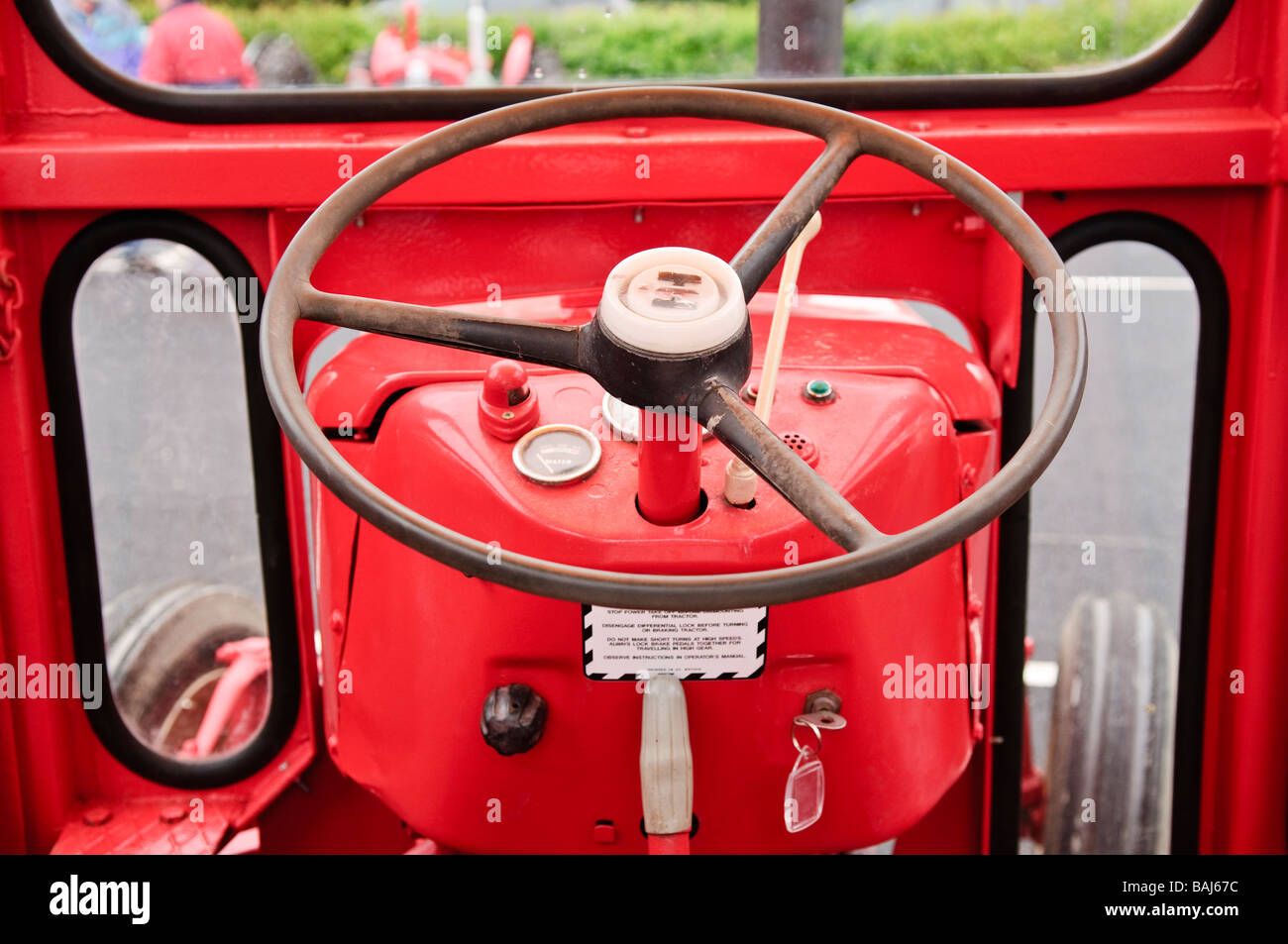 Inside the cab of a red vintage farm tractor showing steering wheel ...