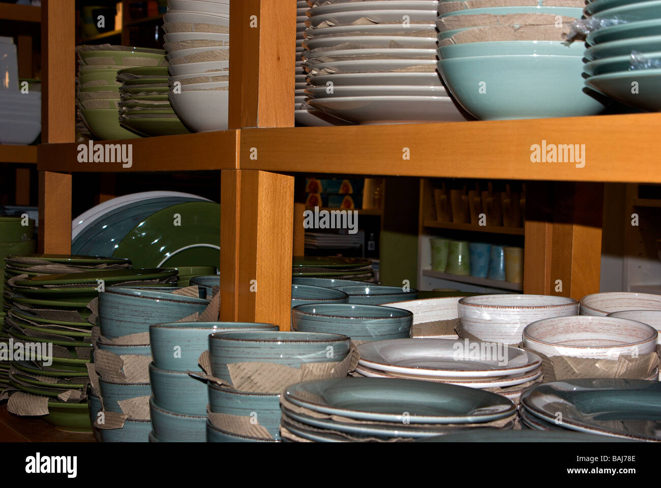 Stacks of round porcelain dinner plates and bowls on display for sale ...