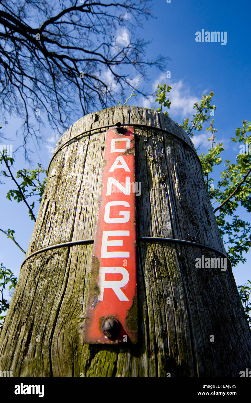 Old electricity pylon stump with danger sign on it Stock Photo - Alamy