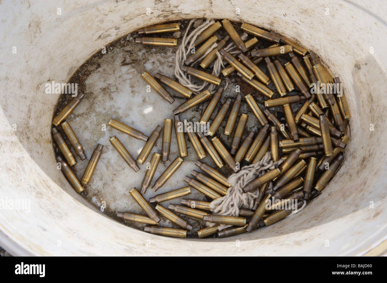 Bucket full of empty rifle shells Stock Photo - Alamy