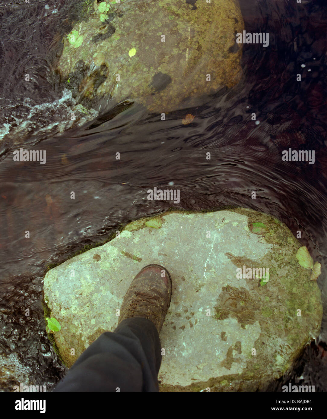 Stepping stones across a river with a walking boot Stock Photo - Alamy