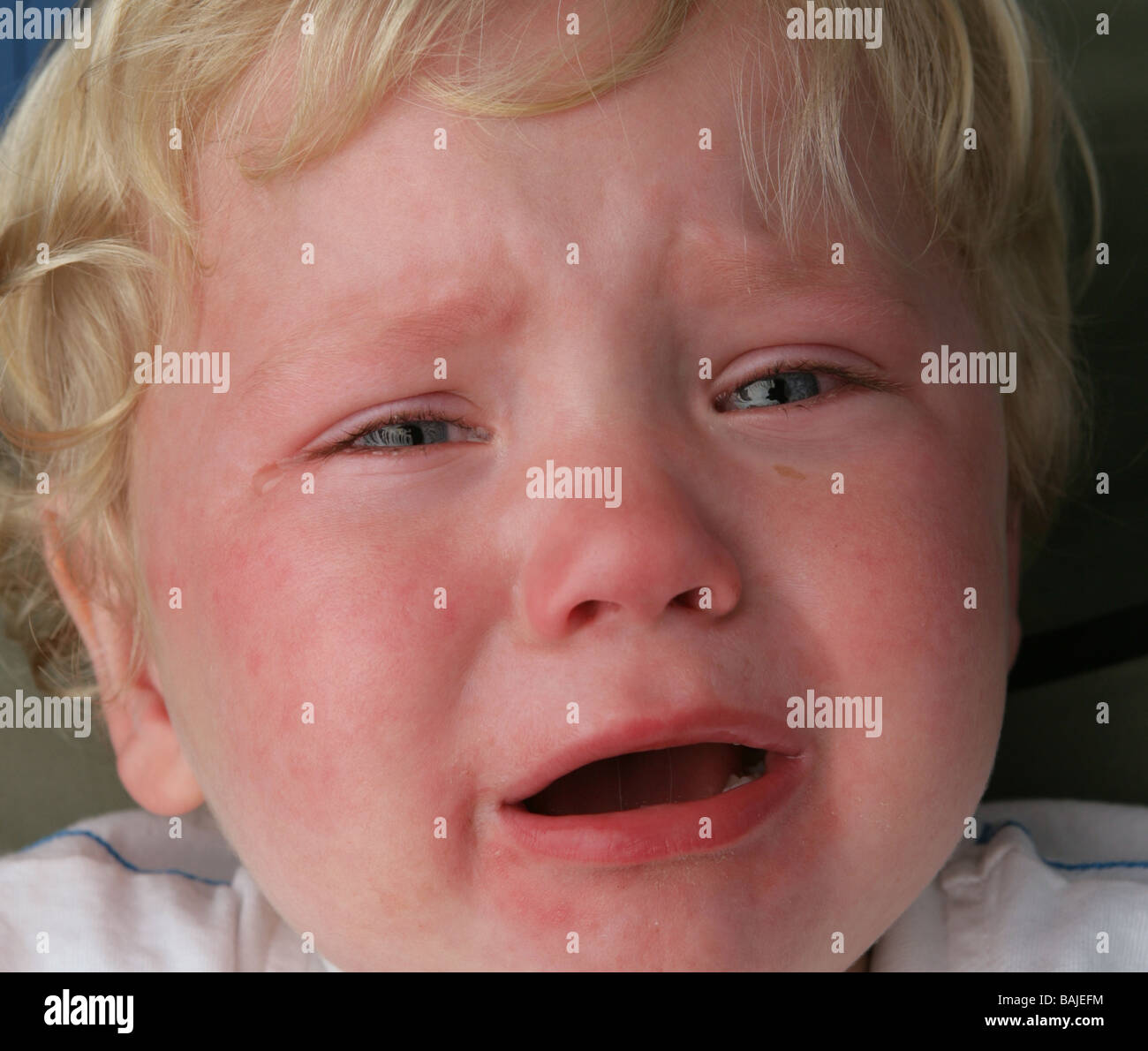 Blonde haired child crying with tears in his eyes Stock Photo - Alamy
