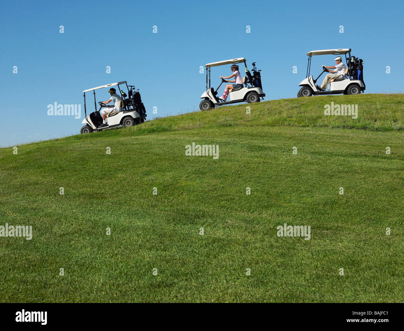 Golfers driving carts Stock Photo - Alamy