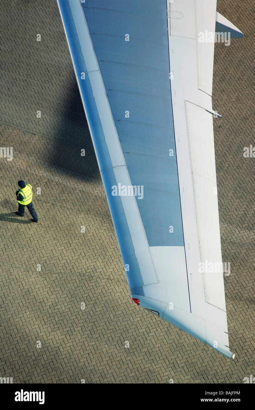 Man walking under airplane wing, elevated view Stock Photo - Alamy
