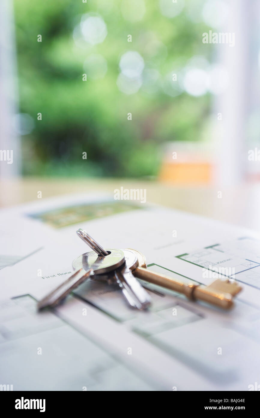 Key ring with three keys lying on architectural blueprints, close-up ...
