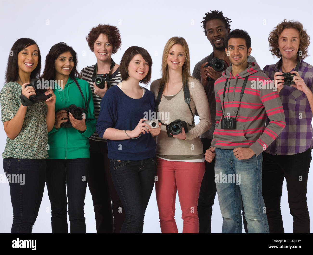 Group portrait of young people holding cameras, studio shot Stock Photo ...