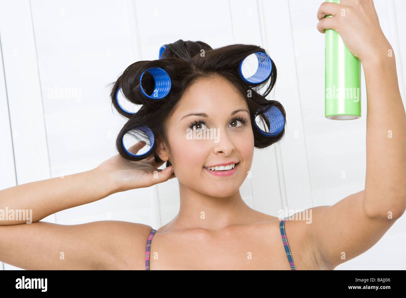 Woman applying hair spray Stock Photo - Alamy
