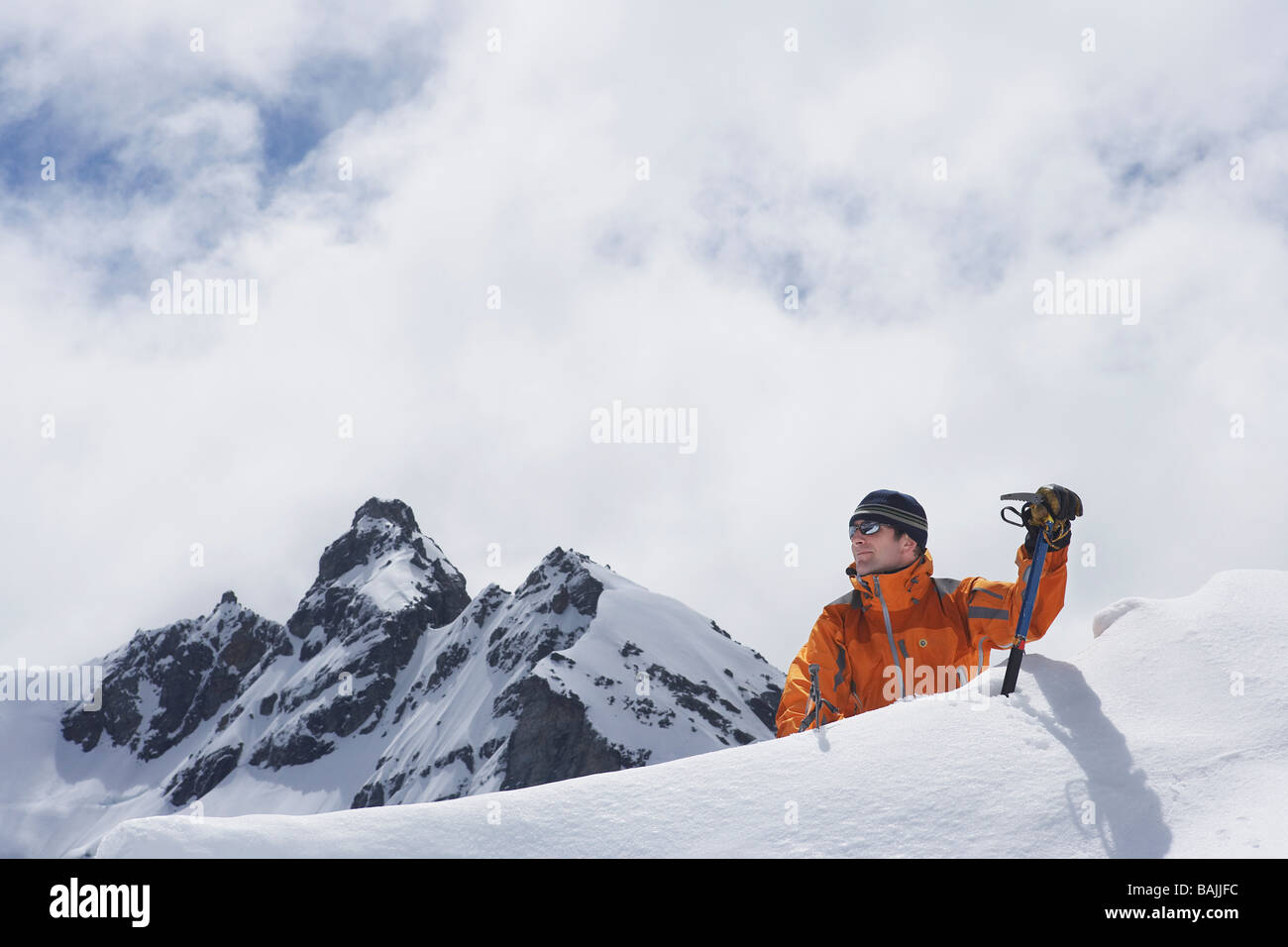 Mountain climber coming over peak Stock Photo - Alamy