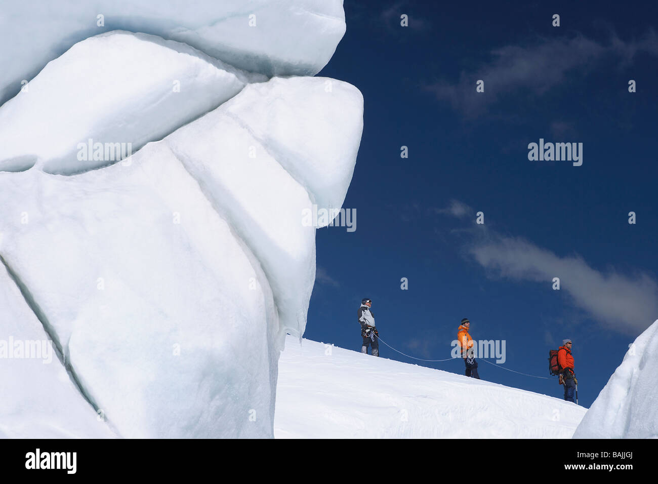 Mountain climbers hiking past ice formation Stock Photo - Alamy
