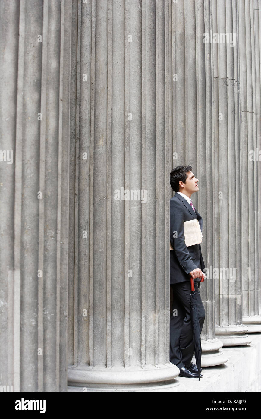 Businessman outside building looking up at sky Stock Photo - Alamy
