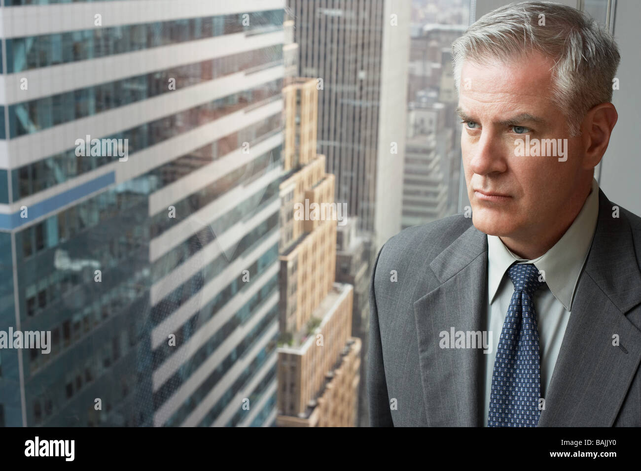 Businessman by office window Stock Photo - Alamy