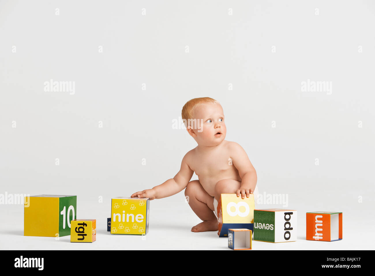 Baby Picking Up Blocks Stock Photo - Alamy