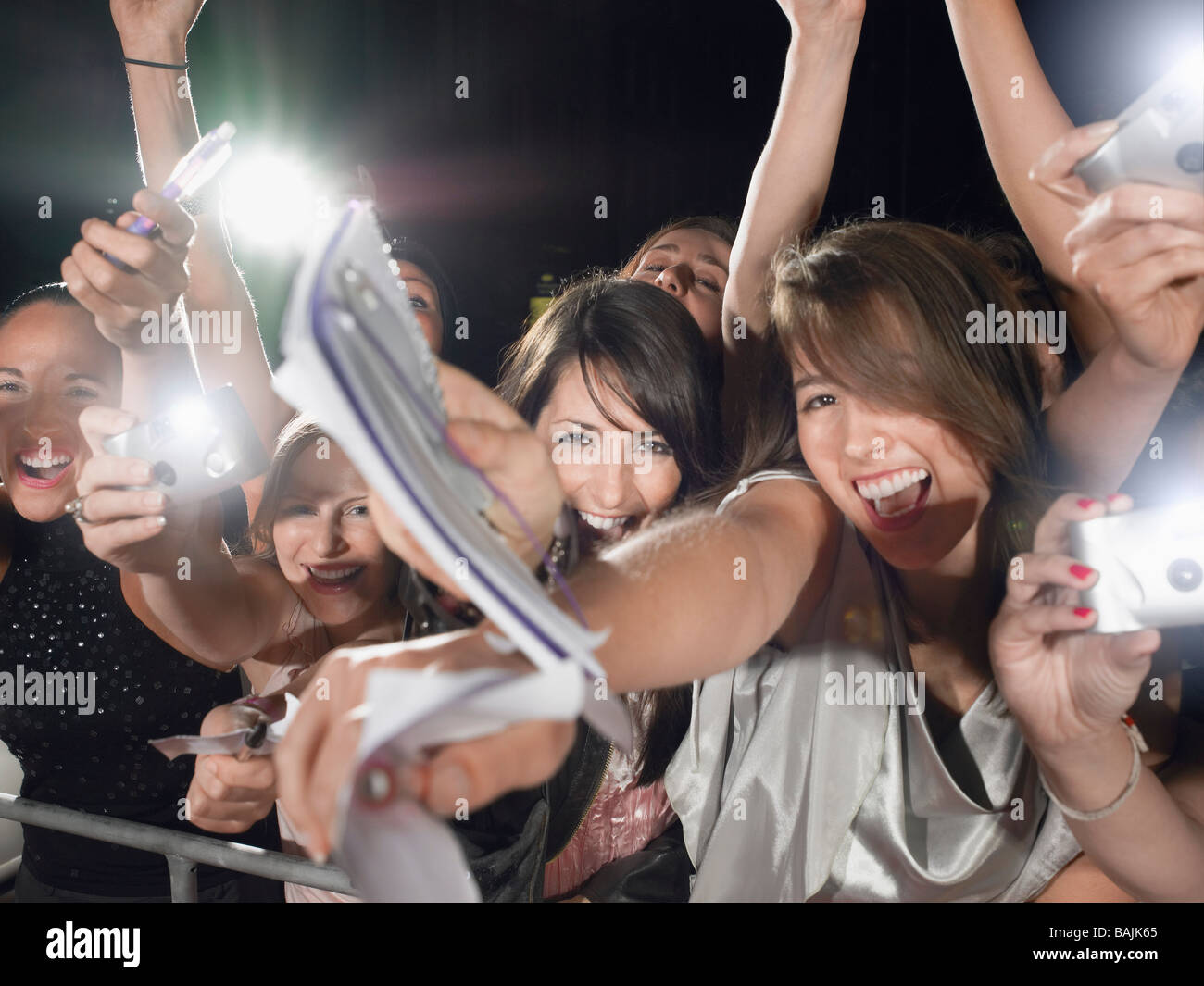 Fans leaning over barrier Stock Photo - Alamy
